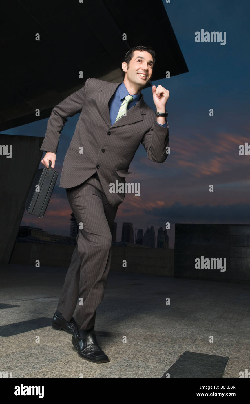 Businessman running with a briefcase Stock Photo - Alamy