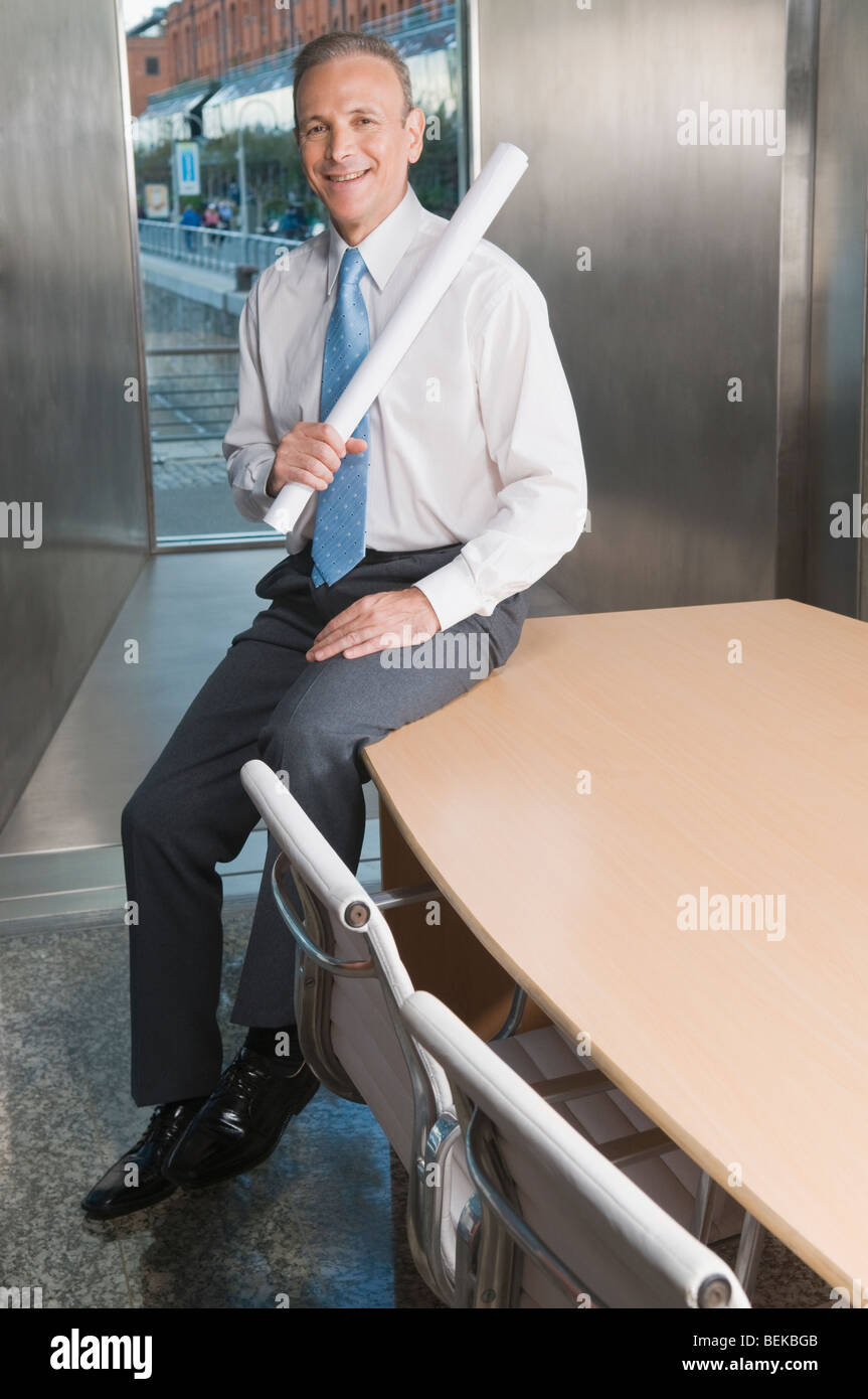 Businessman holding a chart and smiling in a board room Stock Photo - Alamy