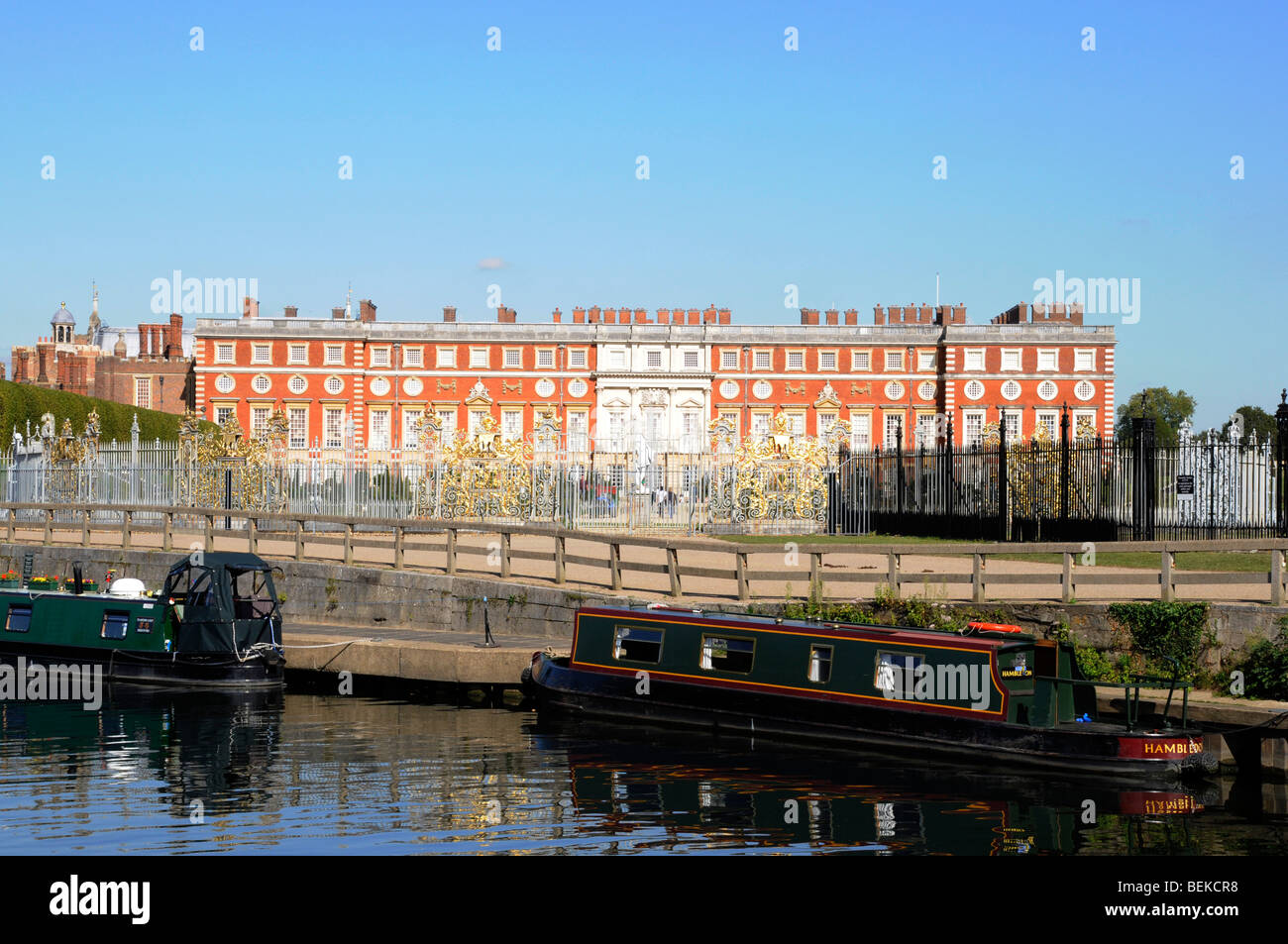 Canal boats moored up in front of Hampton Court Palace on blue skied ...