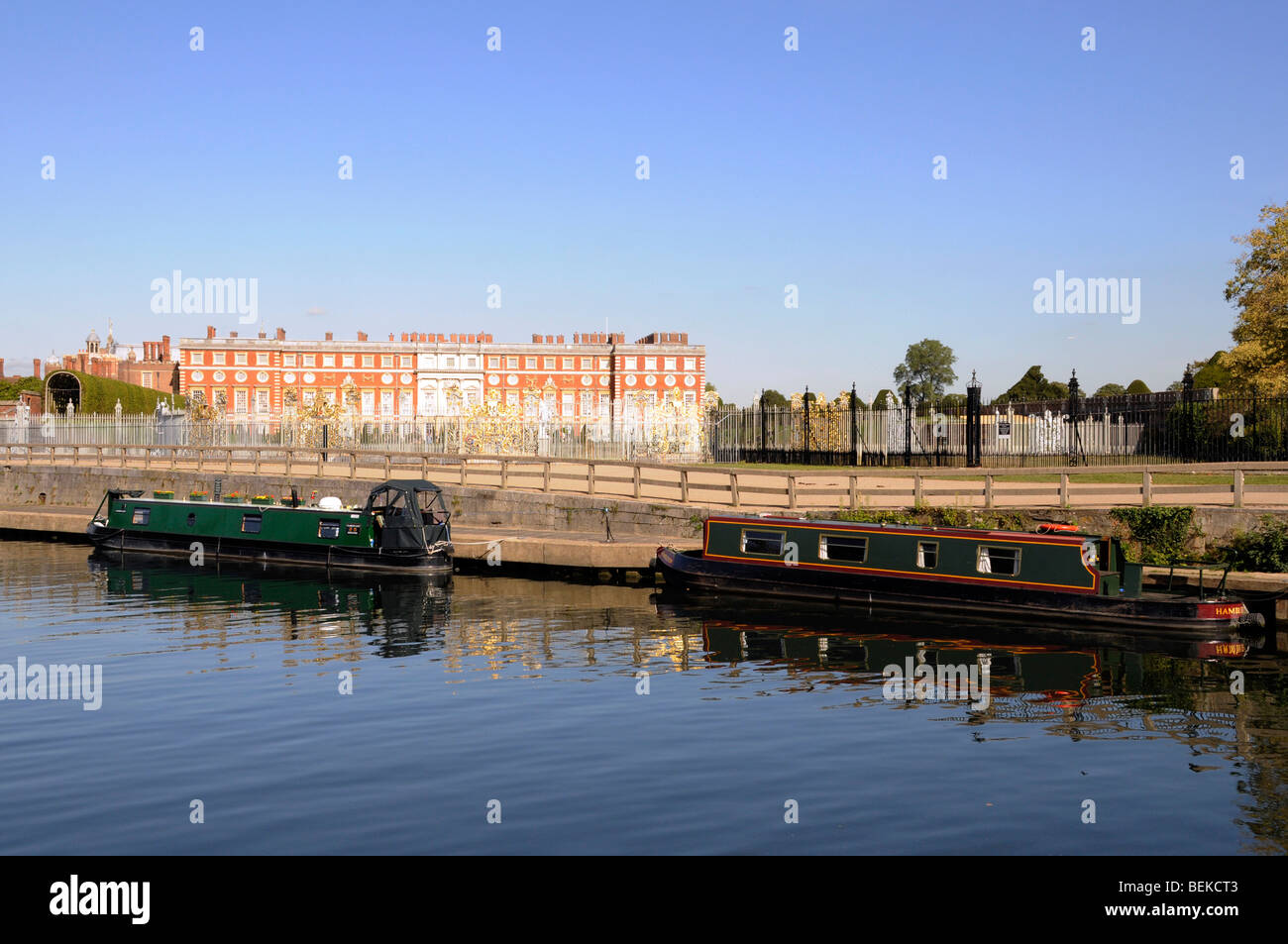 Canal boats moored up in front of Hampton Court Palace on blue skied ...