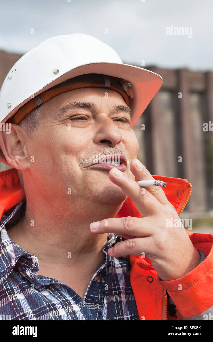 Happy senior construction worker smoking outdoors Stock Photo - Alamy Happy senior construction worker smoking outdoors Stock Photo - Alamy