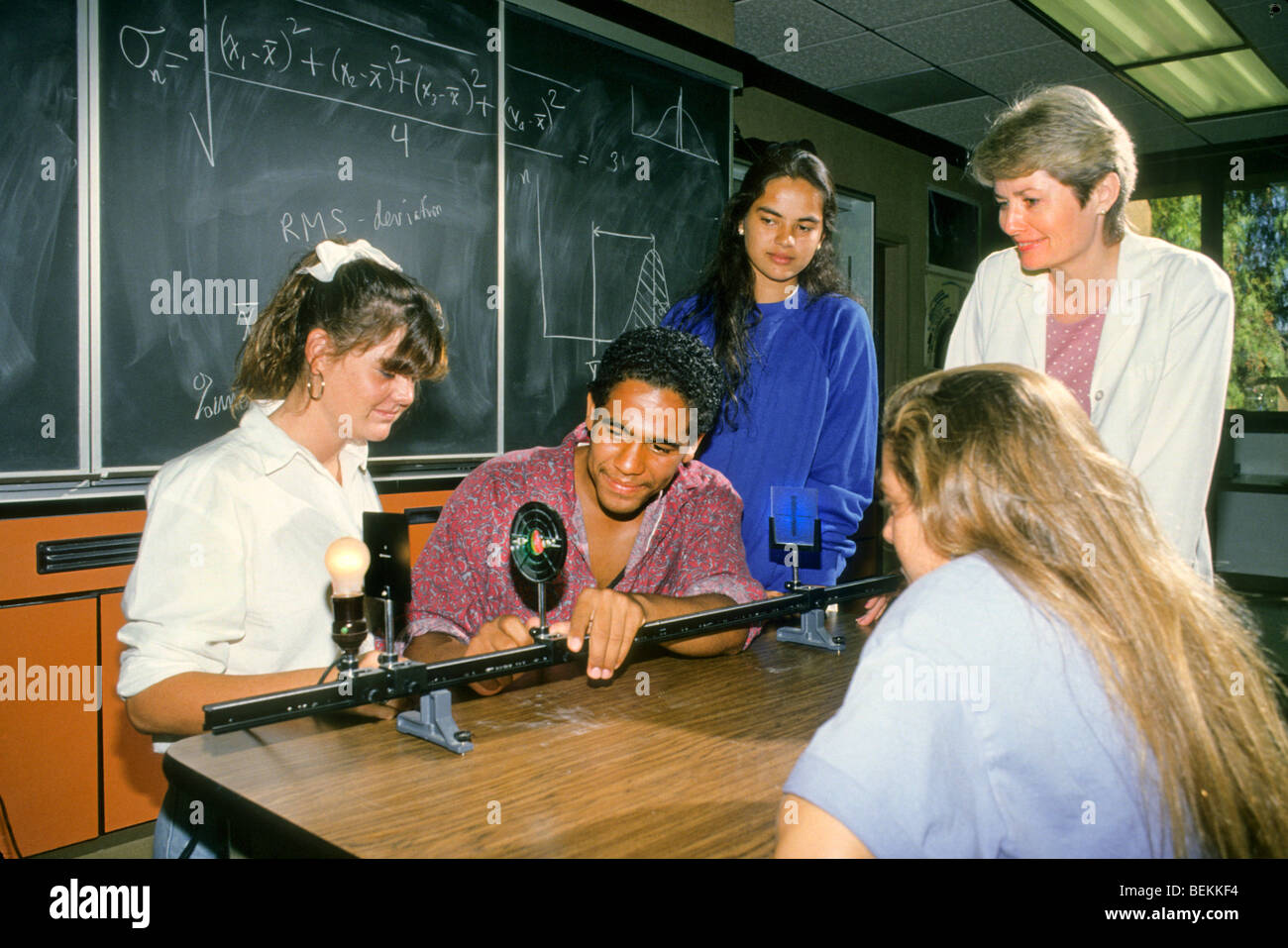 High school science teacher observes students conducting optical ...