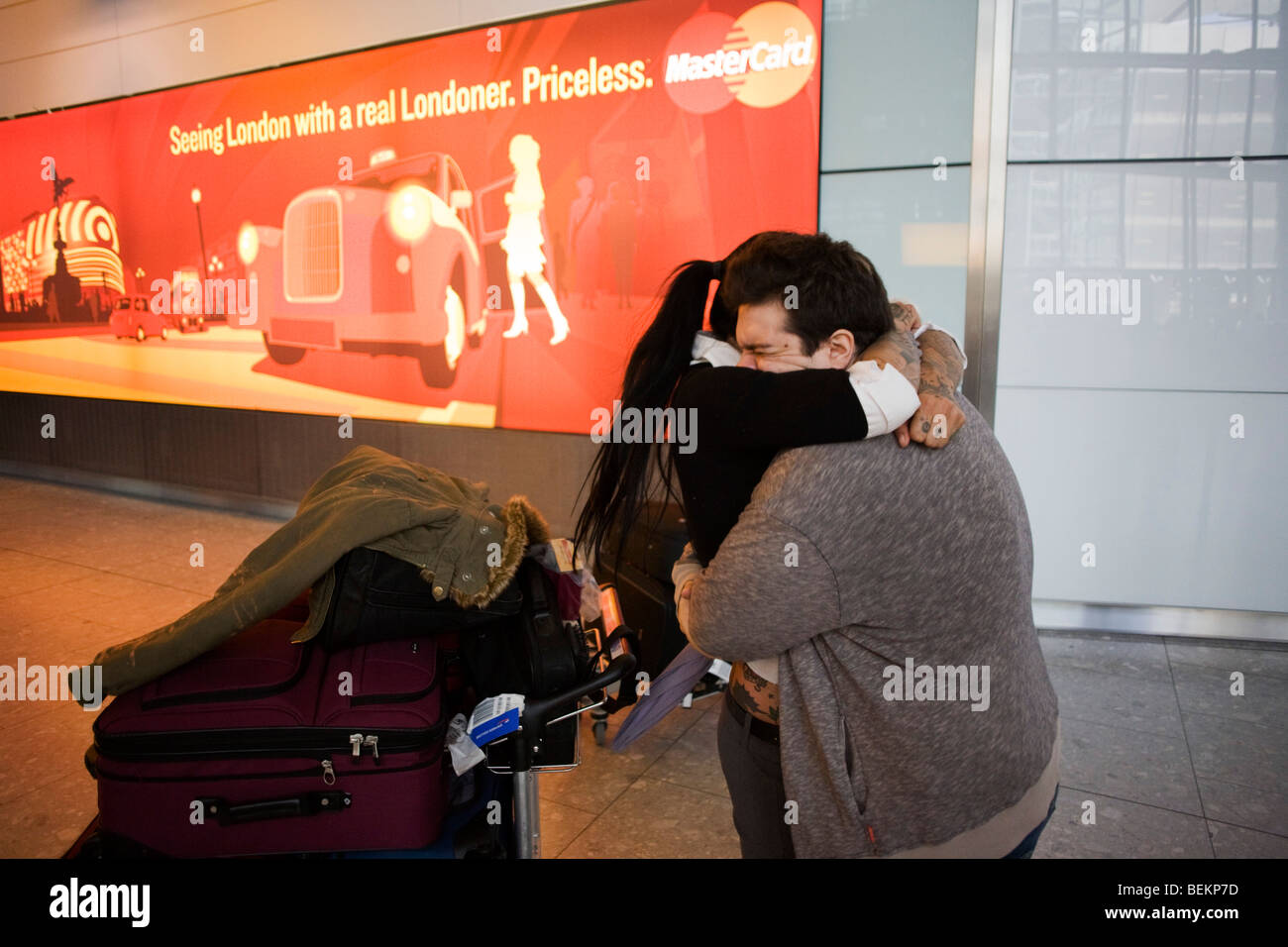 By A Mastercard ad, two friends hold on to each other in arrivals of ...