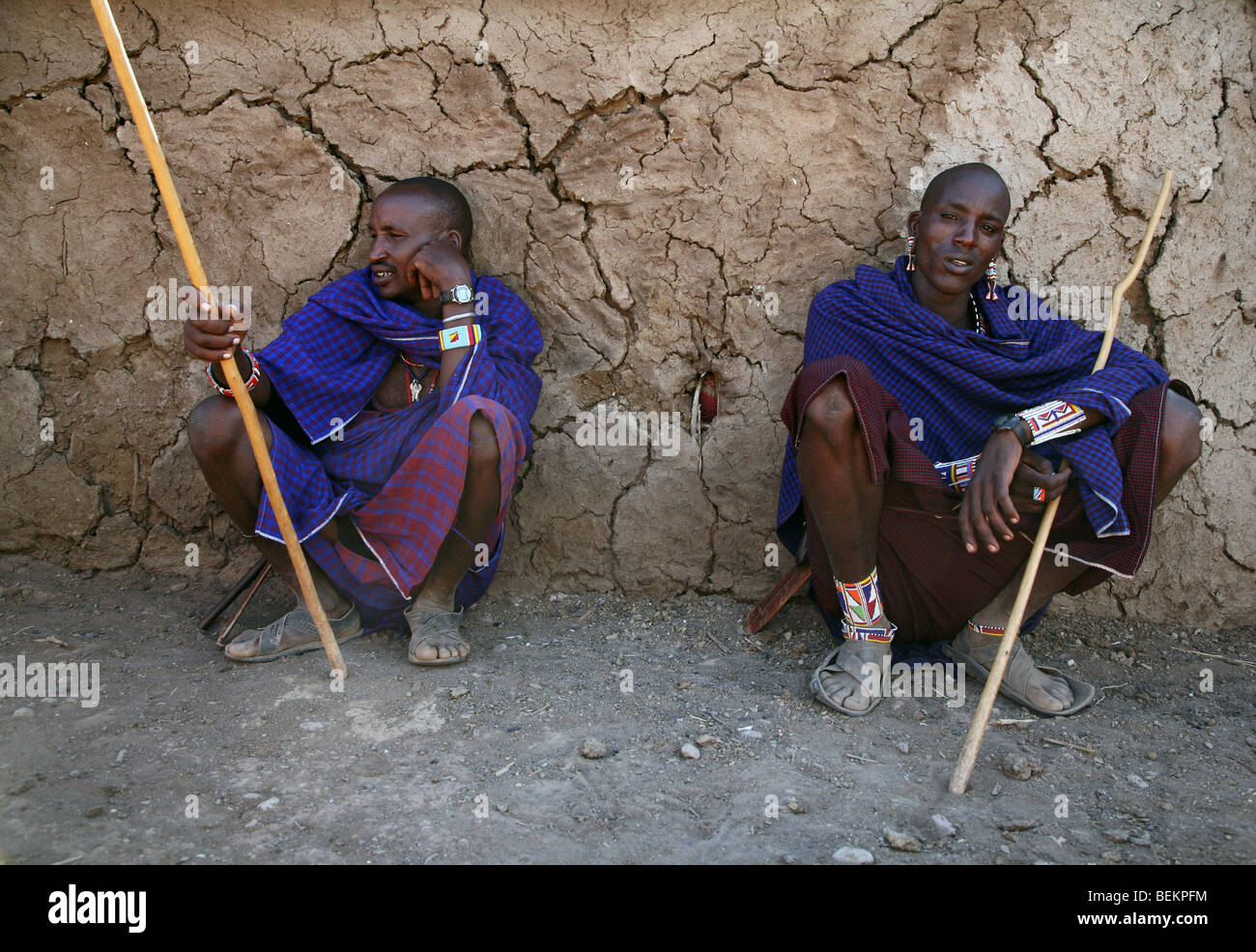 Masai men rest against a hut wall, Amboseli National Park, Kenya, East ...