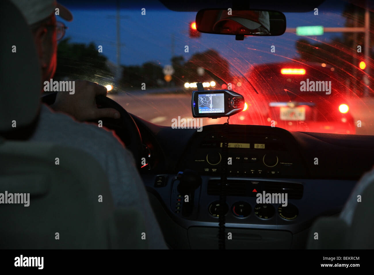 A view of the interior and out the windshield of a car, in traffic, at ...