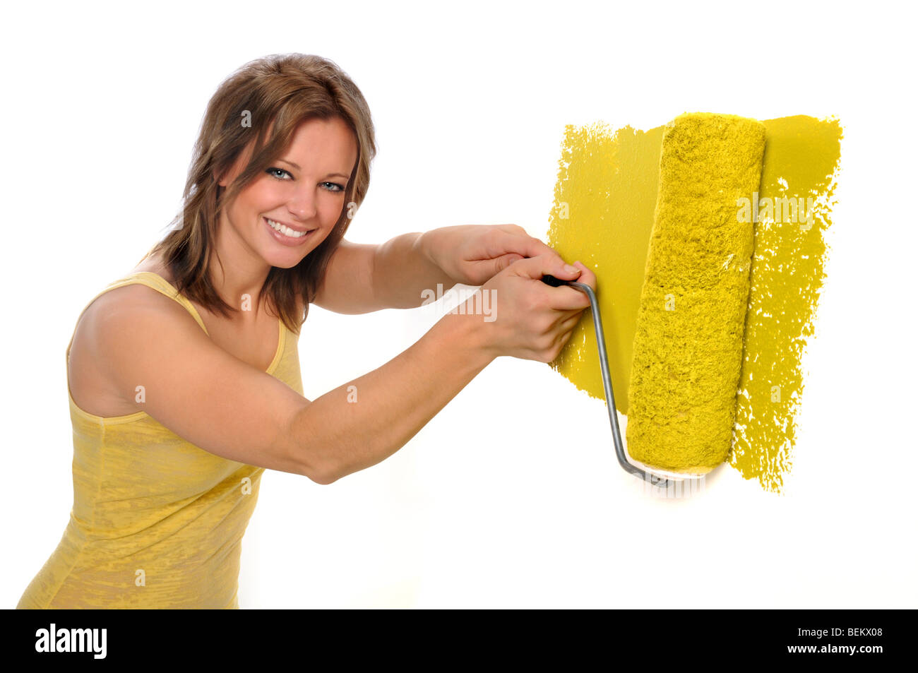 Beautiful woman using paint roller with yellow color Stock Photo - Alamy