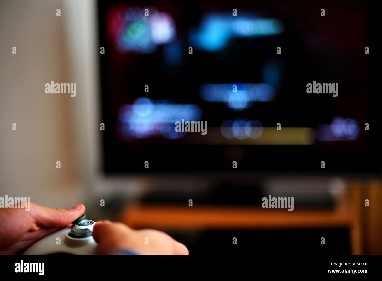 Hands on controller with blured game on TV screen Stock Photo - Alamy