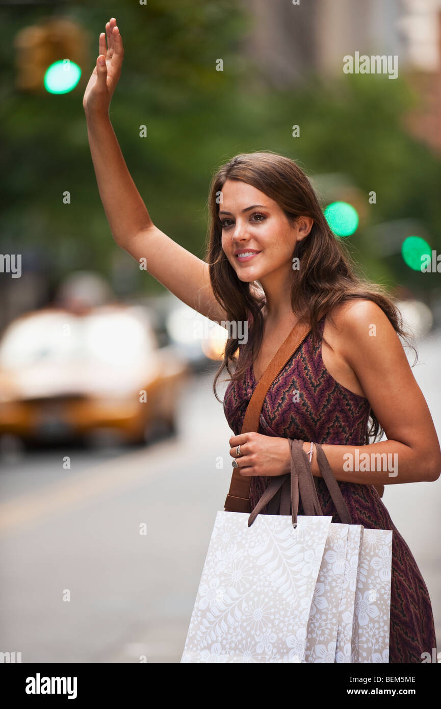 Woman hailing cab Stock Photo - Alamy
