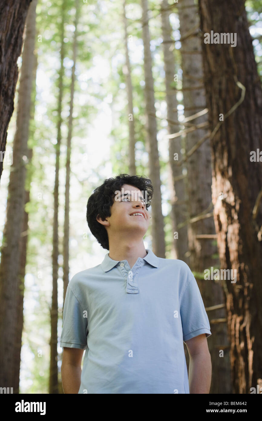 Smiling boy behind tree Stock Photo - Alamy