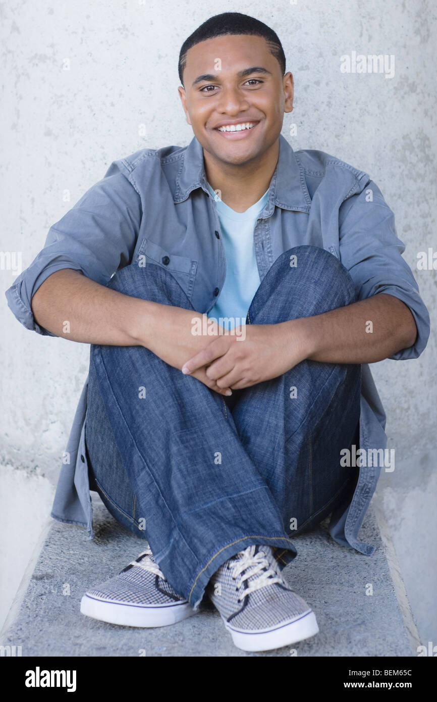 Young man sitting Stock Photo - Alamy