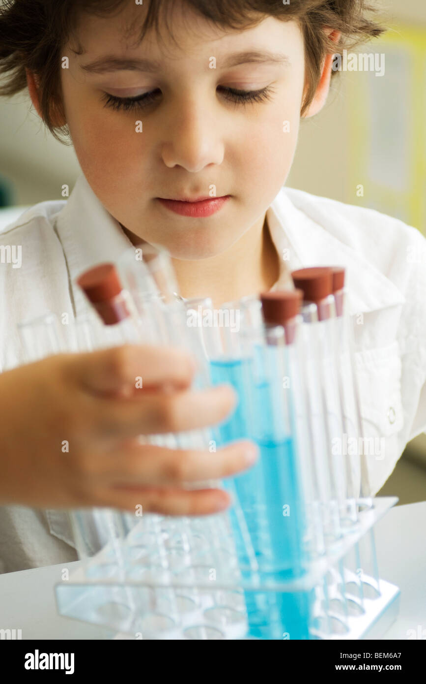 Boy placing test tubes in test tube rack Stock Photo - Alamy