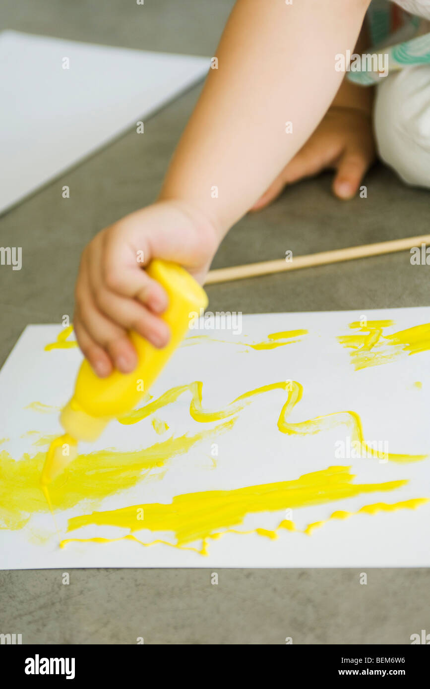 Child squeezing paint onto paper, cropped Stock Photo - Alamy