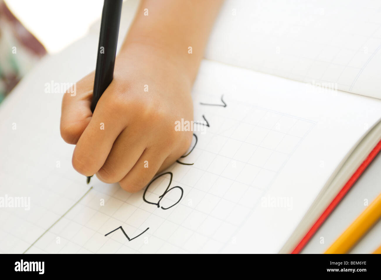 Child's hand writing in notebook Stock Photo - Alamy