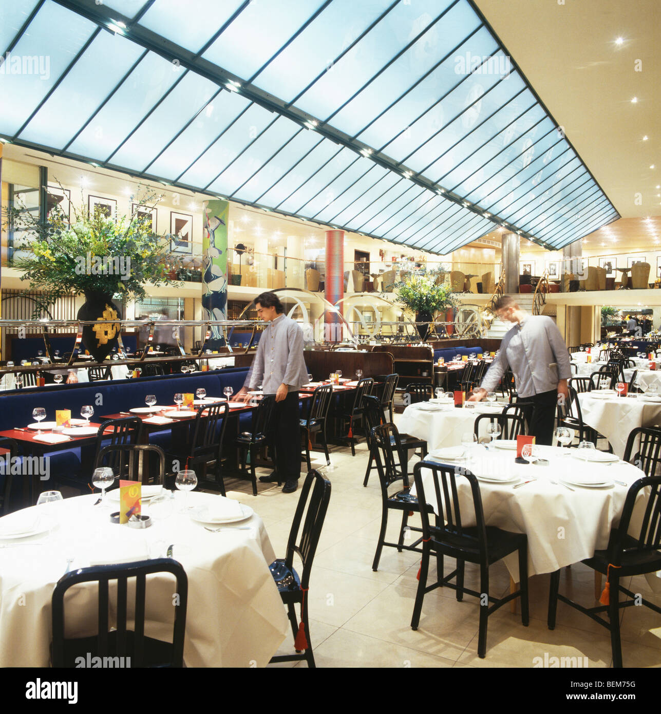 Waiter setting tables at Bluebird restaurant in London designed by ...