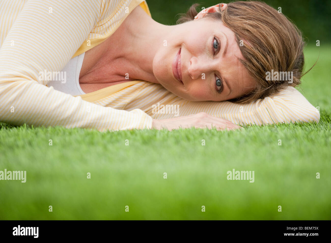 Contented woman lying on grass Stock Photo - Alamy