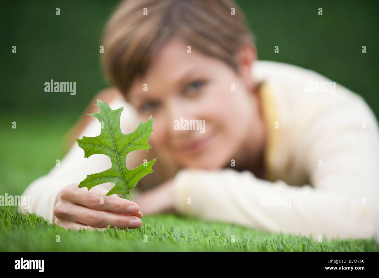 Woman looking at leaf Stock Photo - Alamy