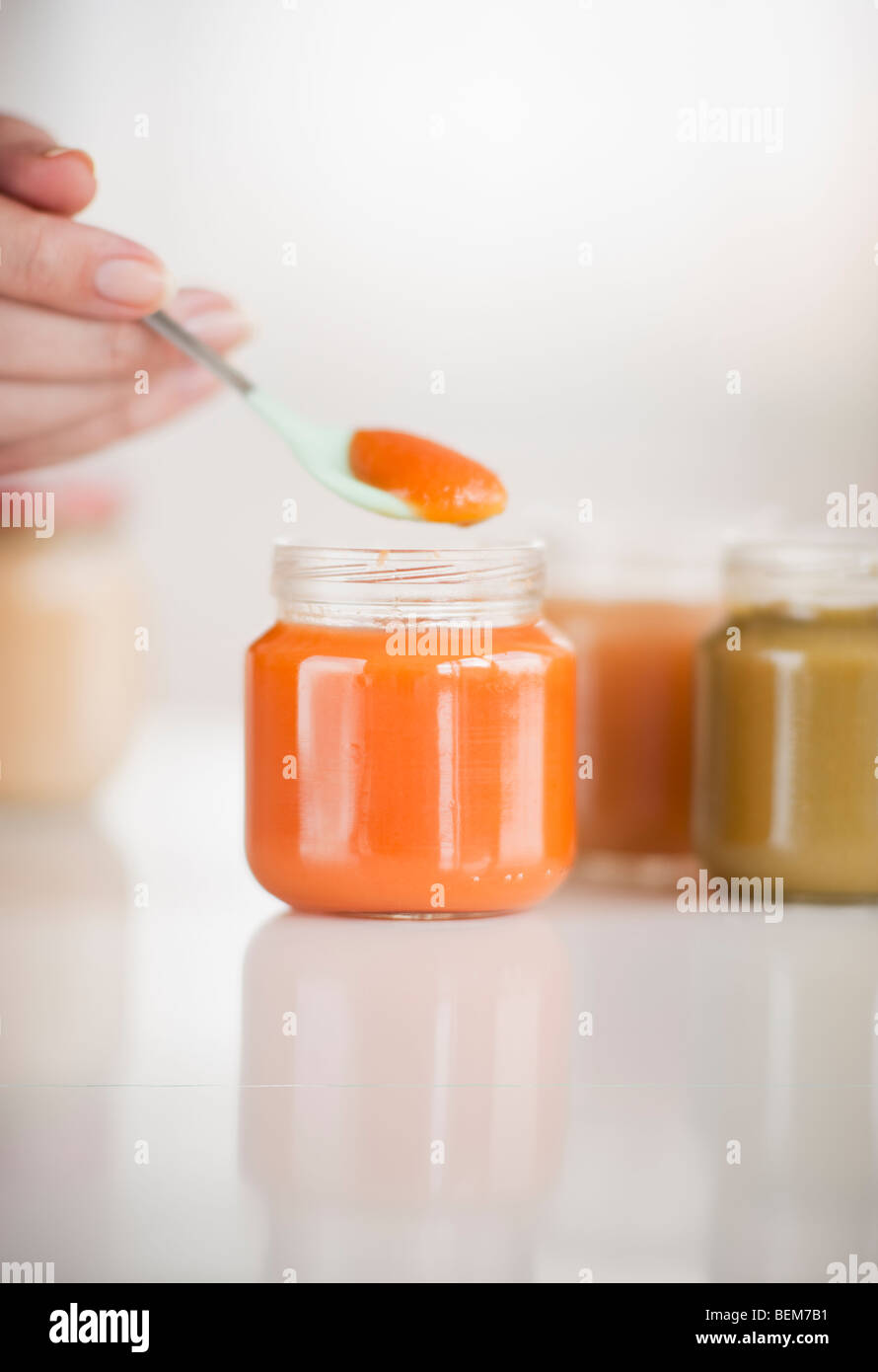 Hand spooning baby food Stock Photo - Alamy