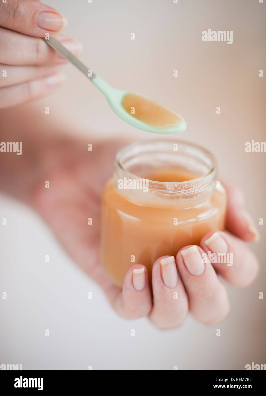 Hand spooning baby food Stock Photo - Alamy
