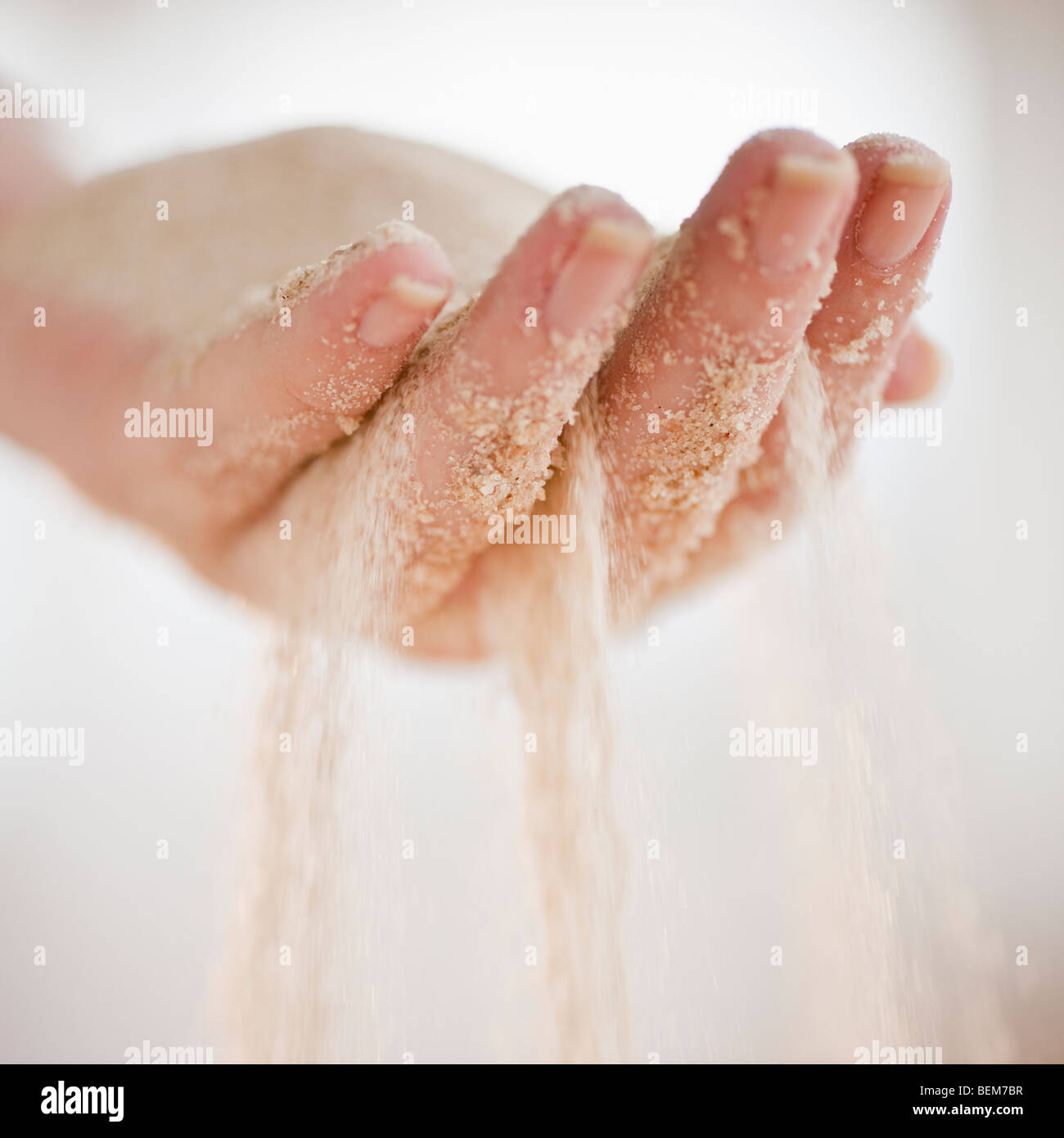 Sand grains falling through hand Stock Photo - Alamy