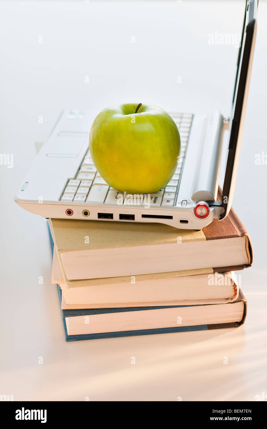 Apple on laptop and books Stock Photo - Alamy