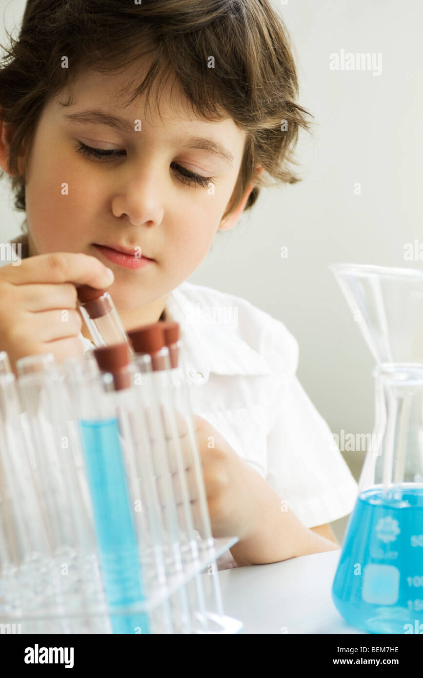 Boy placing test tube into test tube rack Stock Photo - Alamy