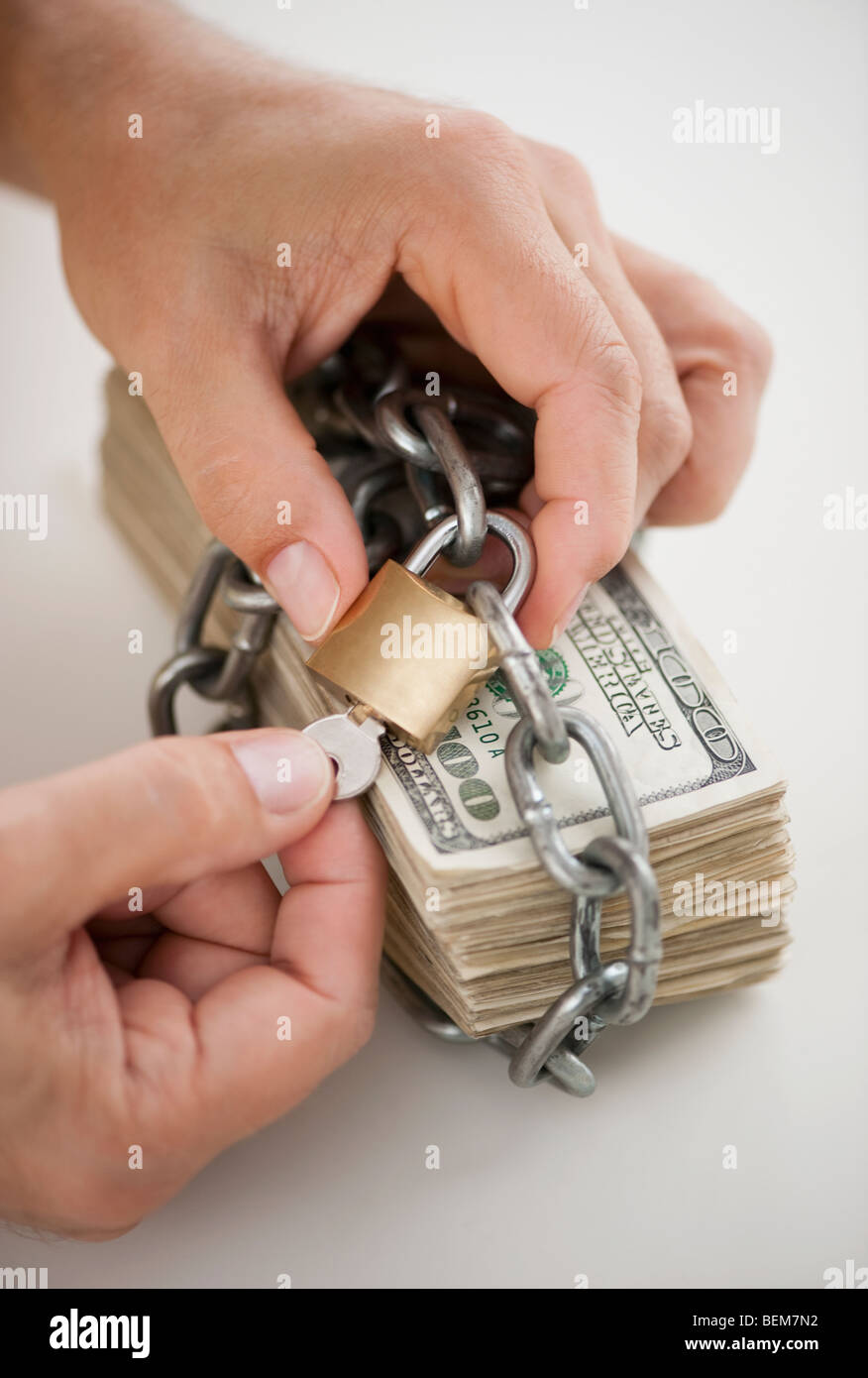 Hands placing lock around money Stock Photo - Alamy