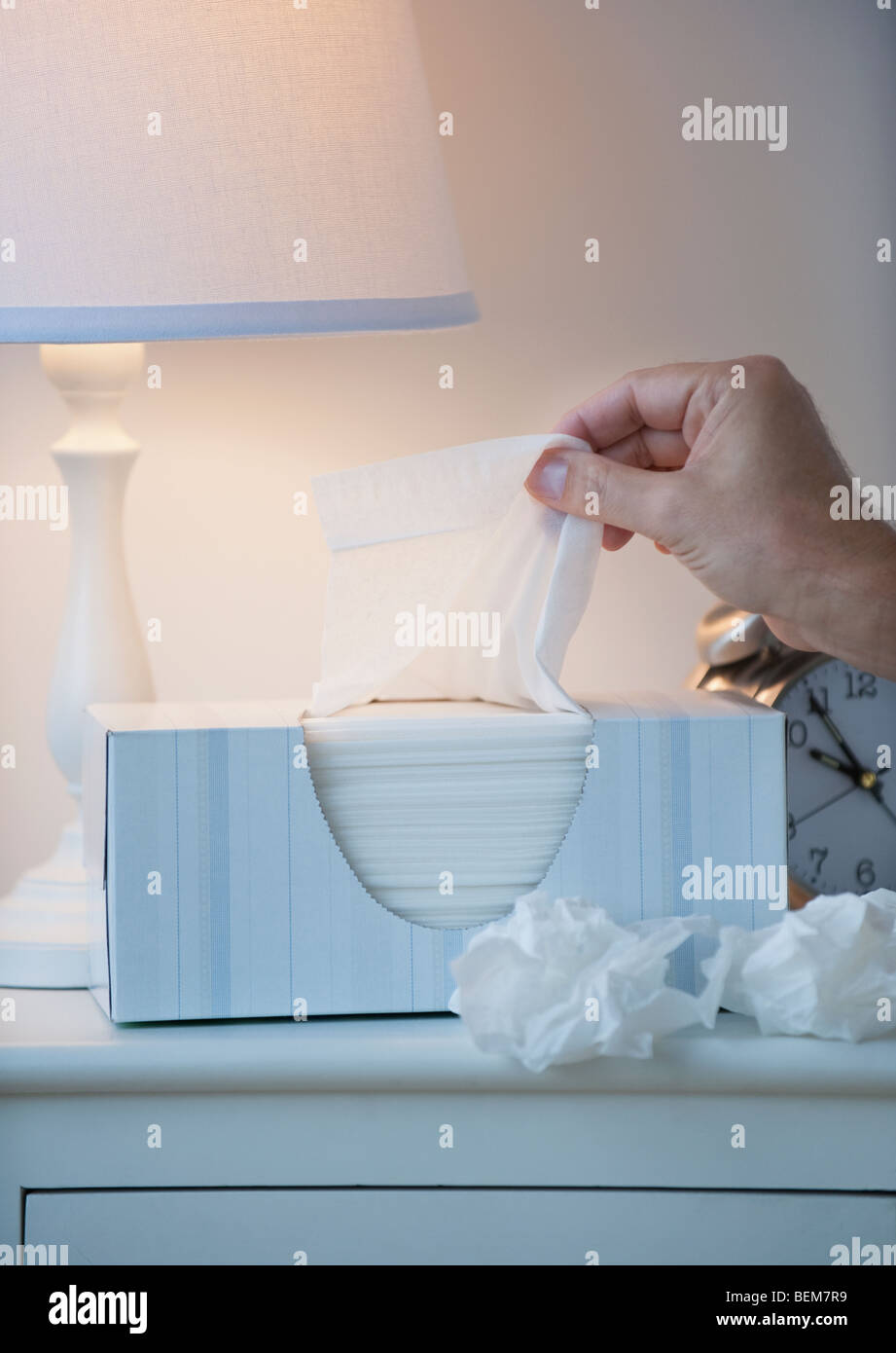 Hand pulling tissue out of box Stock Photo - Alamy