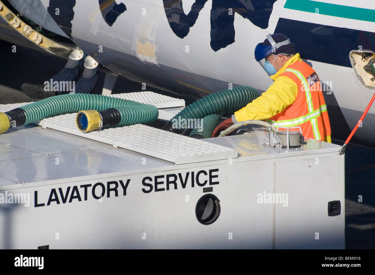 A ground crew worker providing lavatory service for an Boeing airplane ...