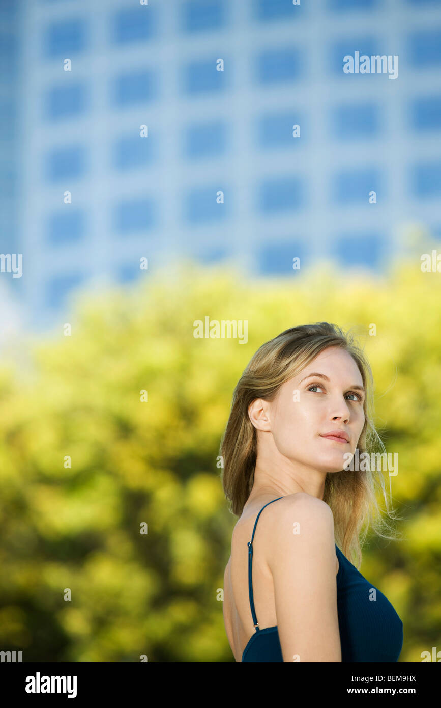 Woman outdoors, looking up dreamily, portrait Stock Photo - Alamy