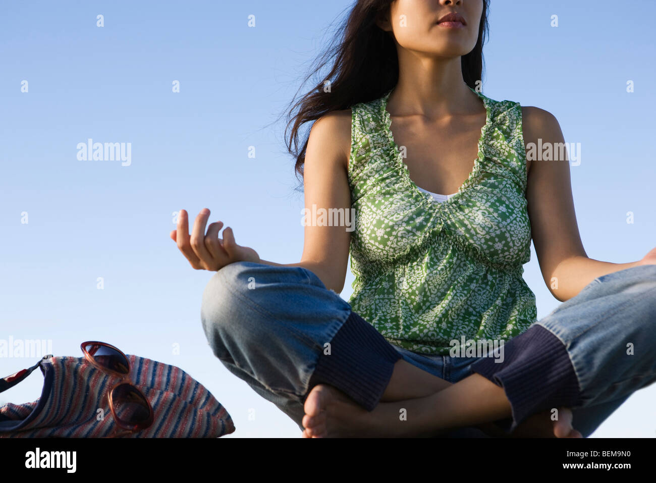 Woman sitting in lotus position outdoors, cropped Stock Photo - Alamy