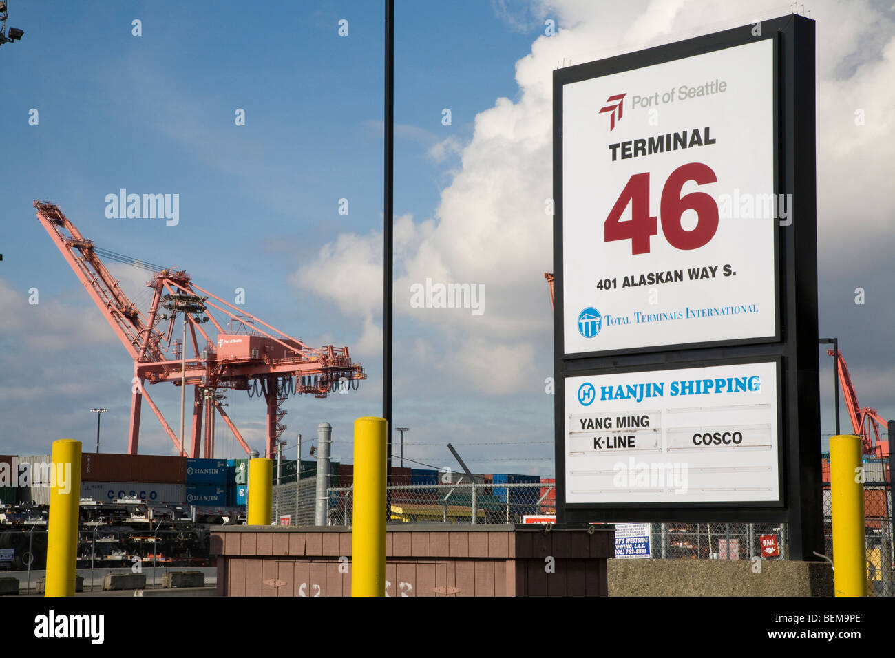 A terminal sign with industrial cranes in the background at Port of ...