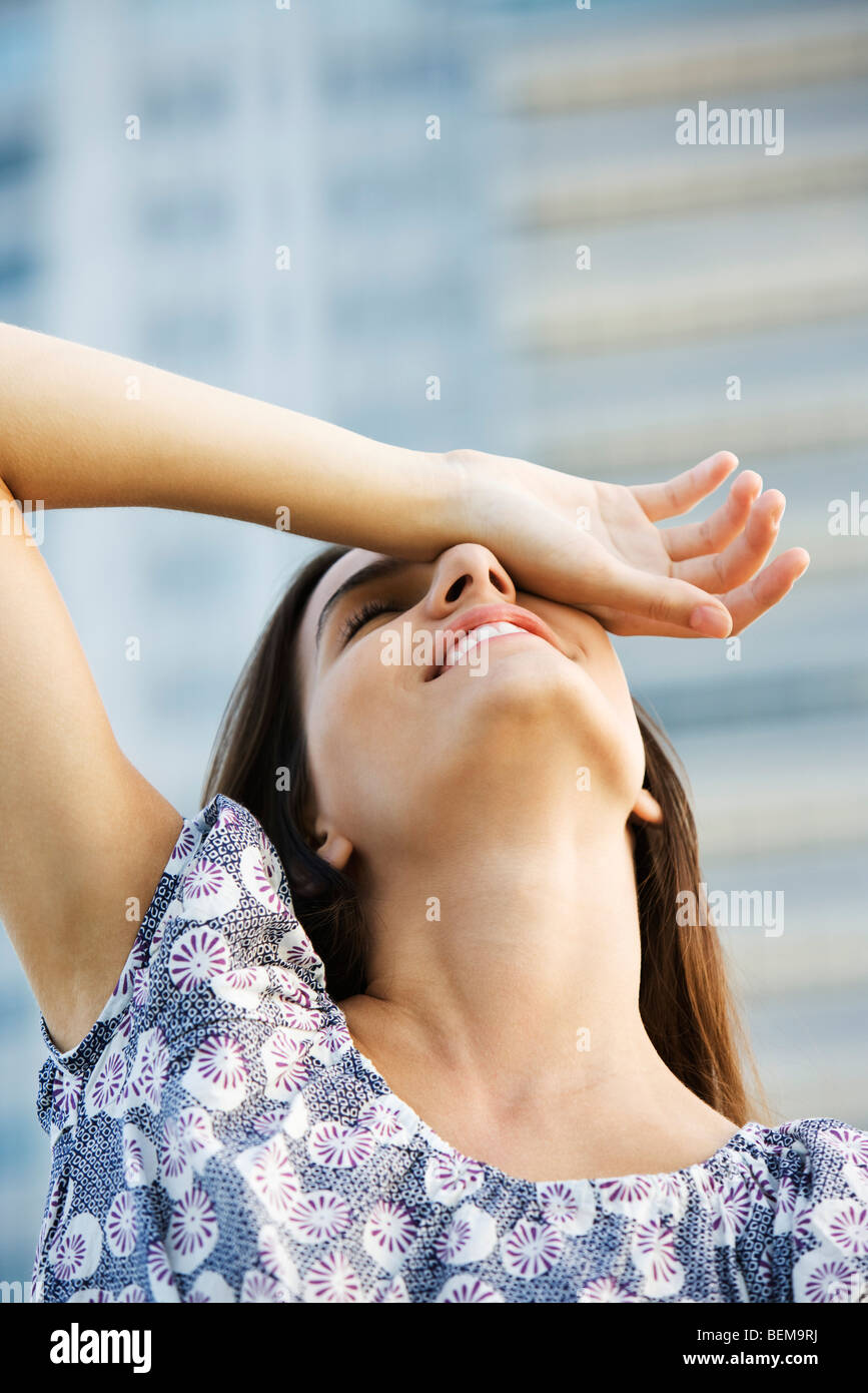Woman holding back of hand over eye, head back Stock Photo - Alamy