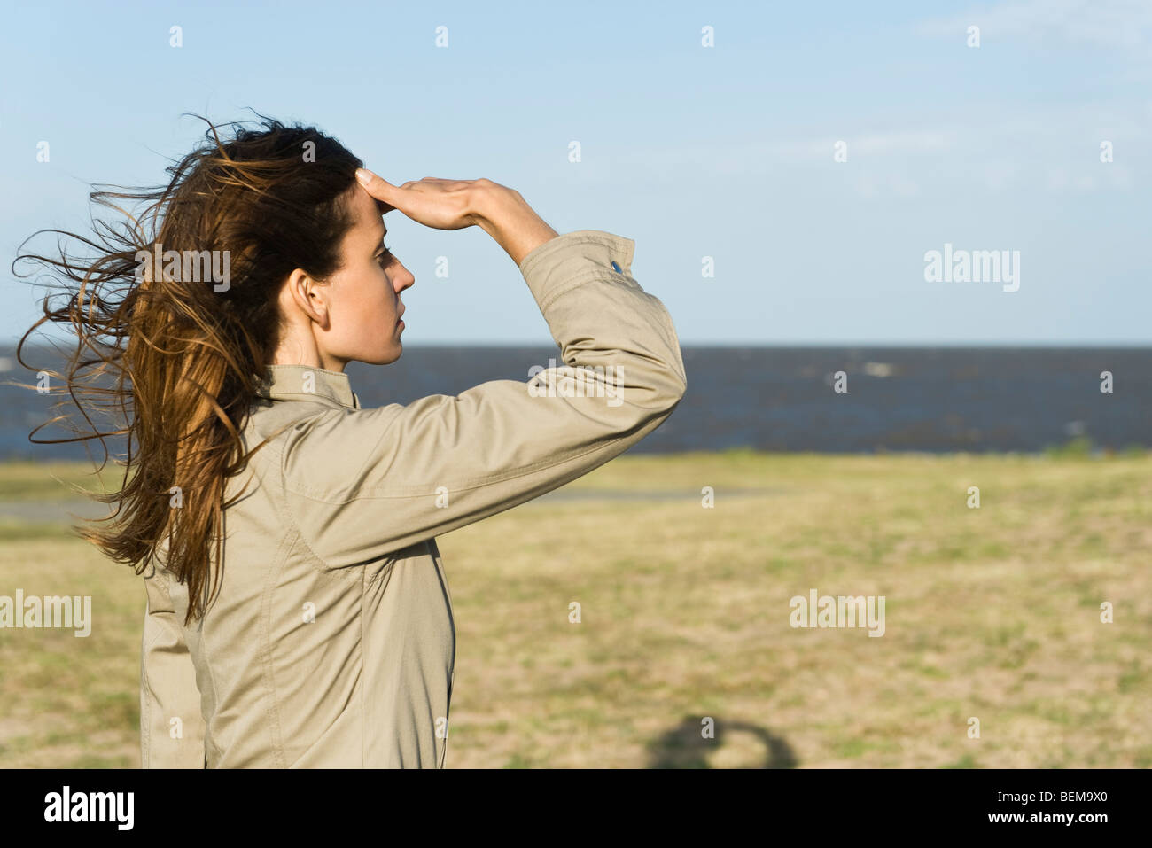 Woman standing in wind looking at the sea Stock Photo - Alamy