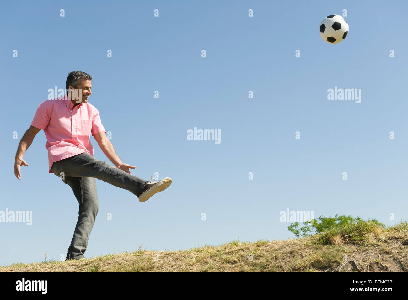 Man playing with soccer ball outdoors, smiling Stock Photo - Alamy