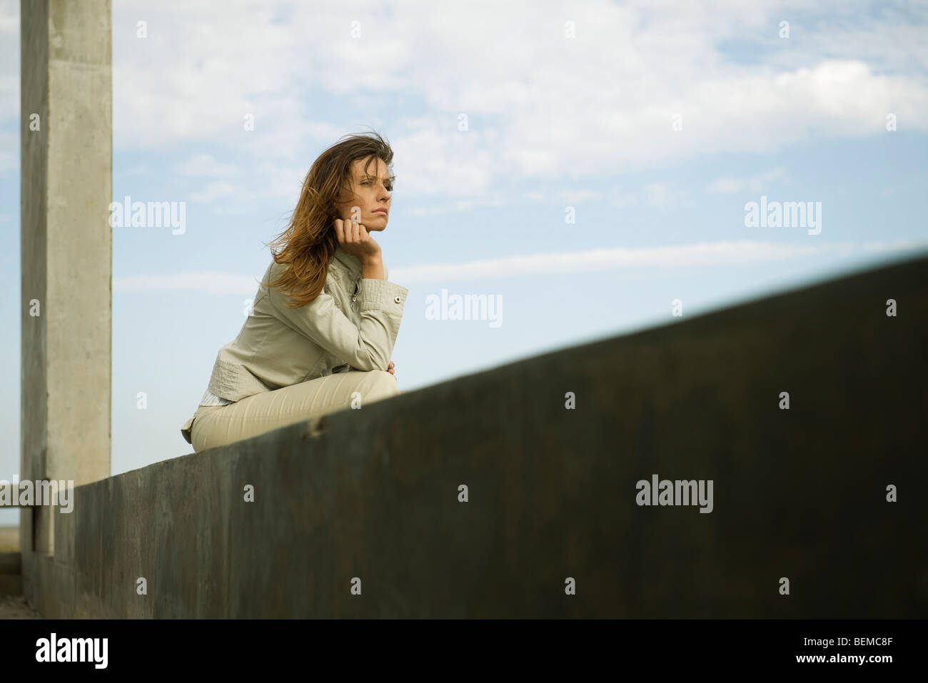 Woman leaning on elbow contemplatively looking away Stock Photo - Alamy