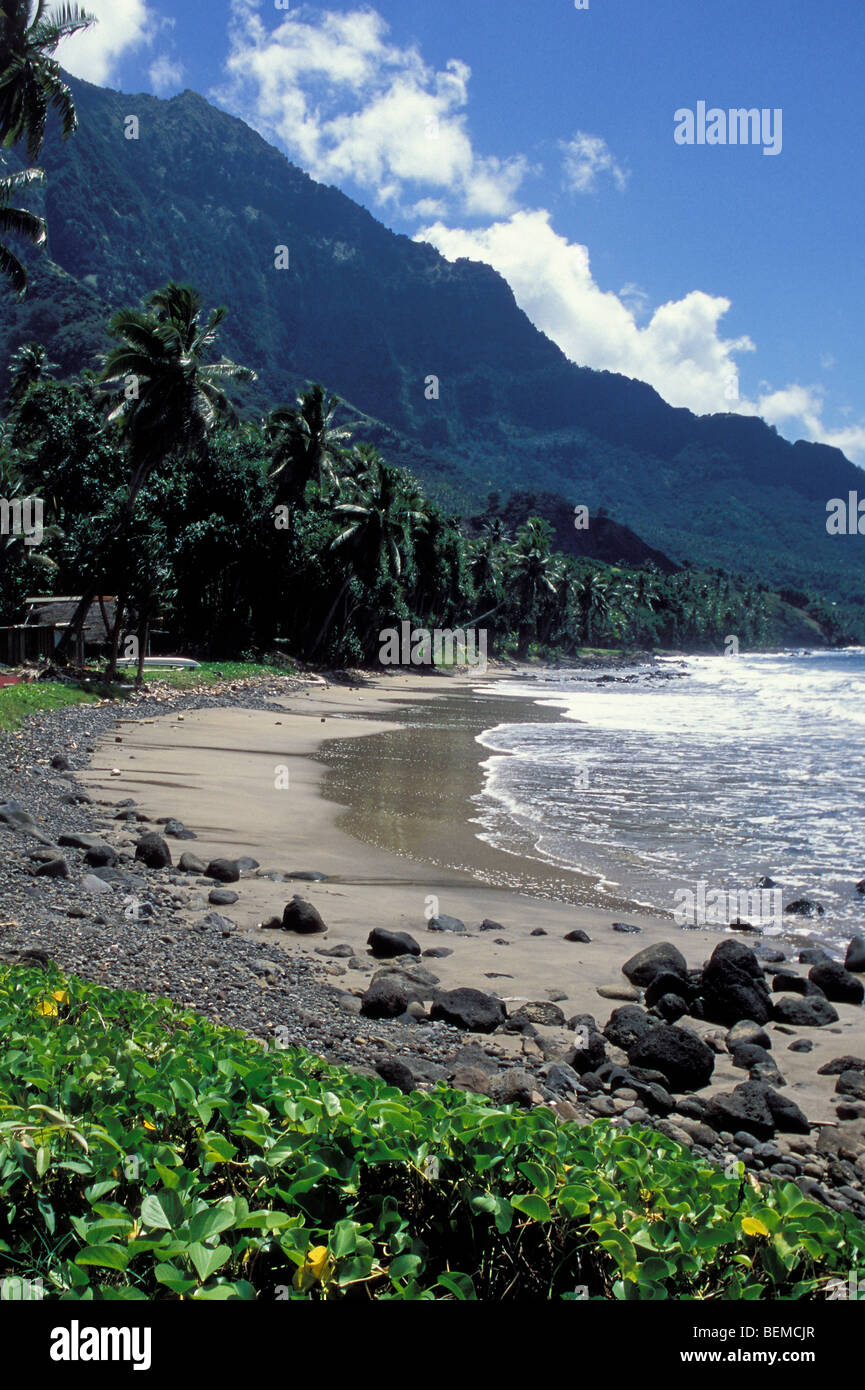 Sand beach with many stones and mountains in background. Hiva Oa ...