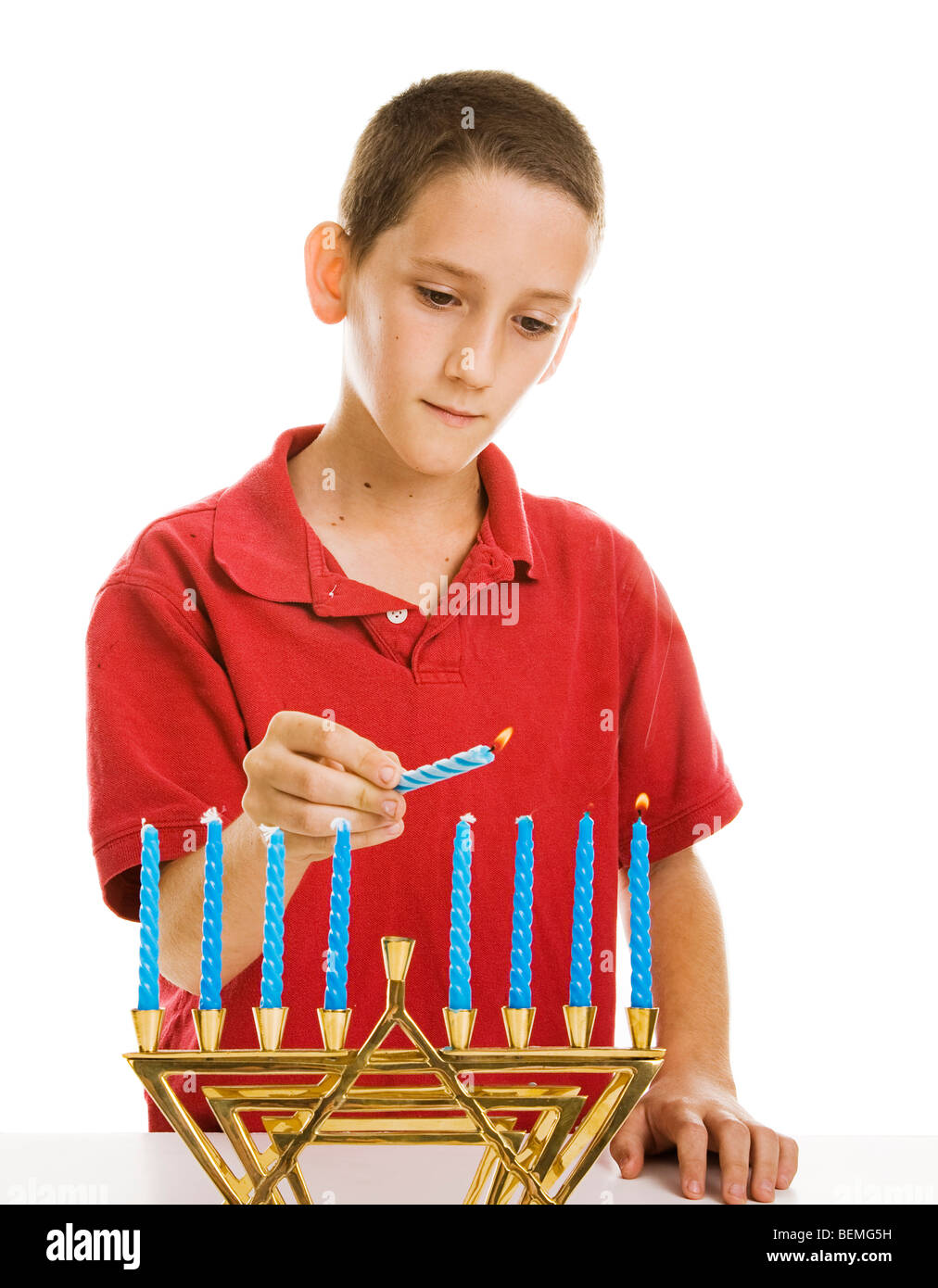 Little boy uses the shamash candle to light the menorah. Isolated on ...
