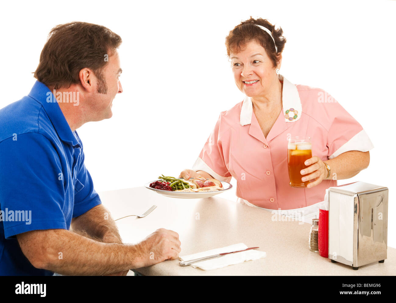 Waitress in a diner serving a turkey dinner to her customer. White ...