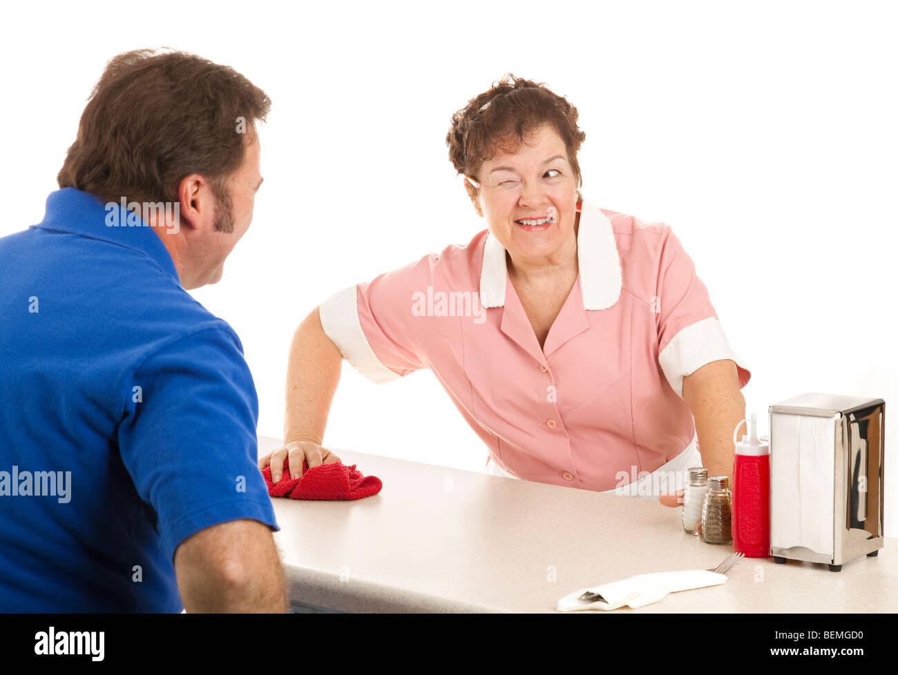 Friendly waitress winks at a customer as she wipes down the lunch ...