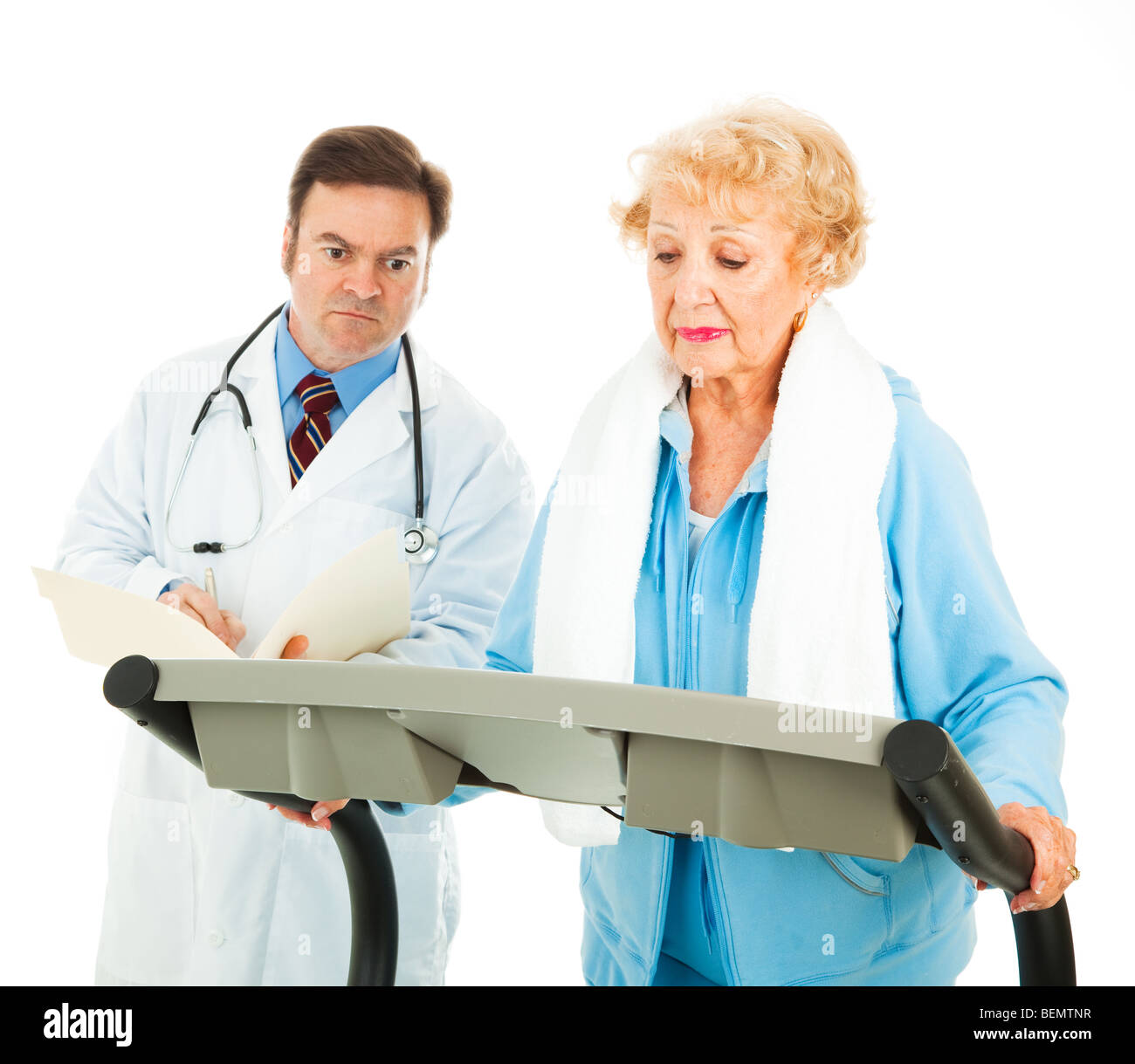 Senior lady walks on treadmill under the supervision of her doctor ...