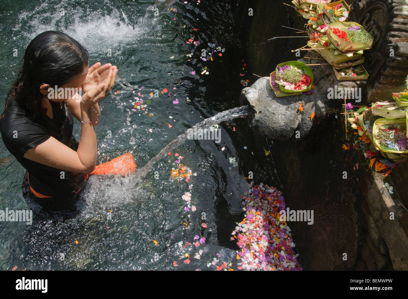 pilgrim taking a bath at the holy spring and temple of Tirta Empul in ...