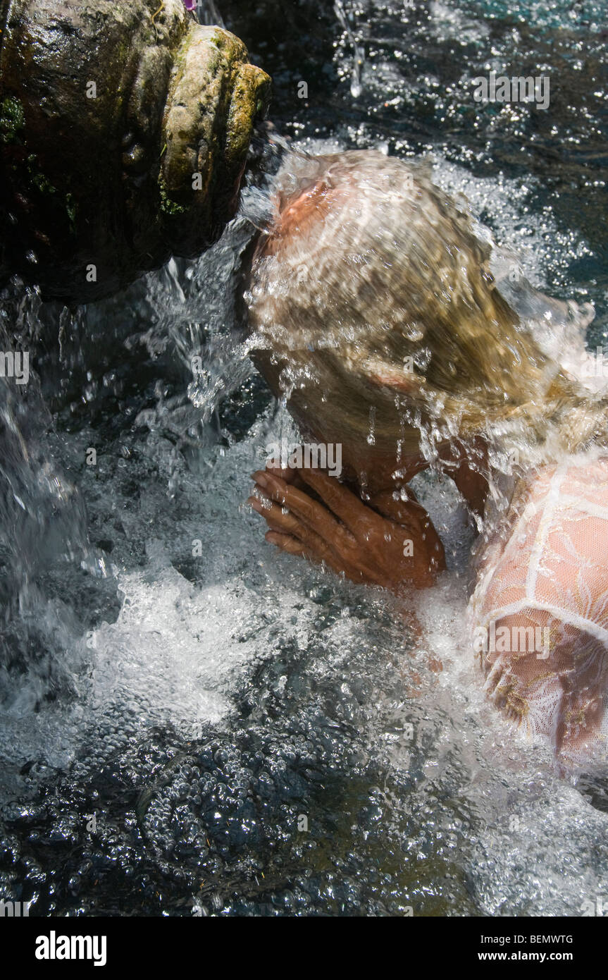 pilgrim taking a bath at the holy spring and temple of Tirta Empul in ...