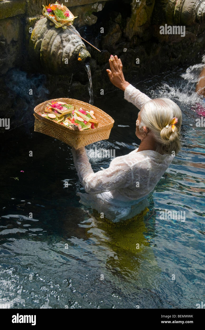 pilgrim taking a bath at the holy spring and temple of Tirta Empul in ...