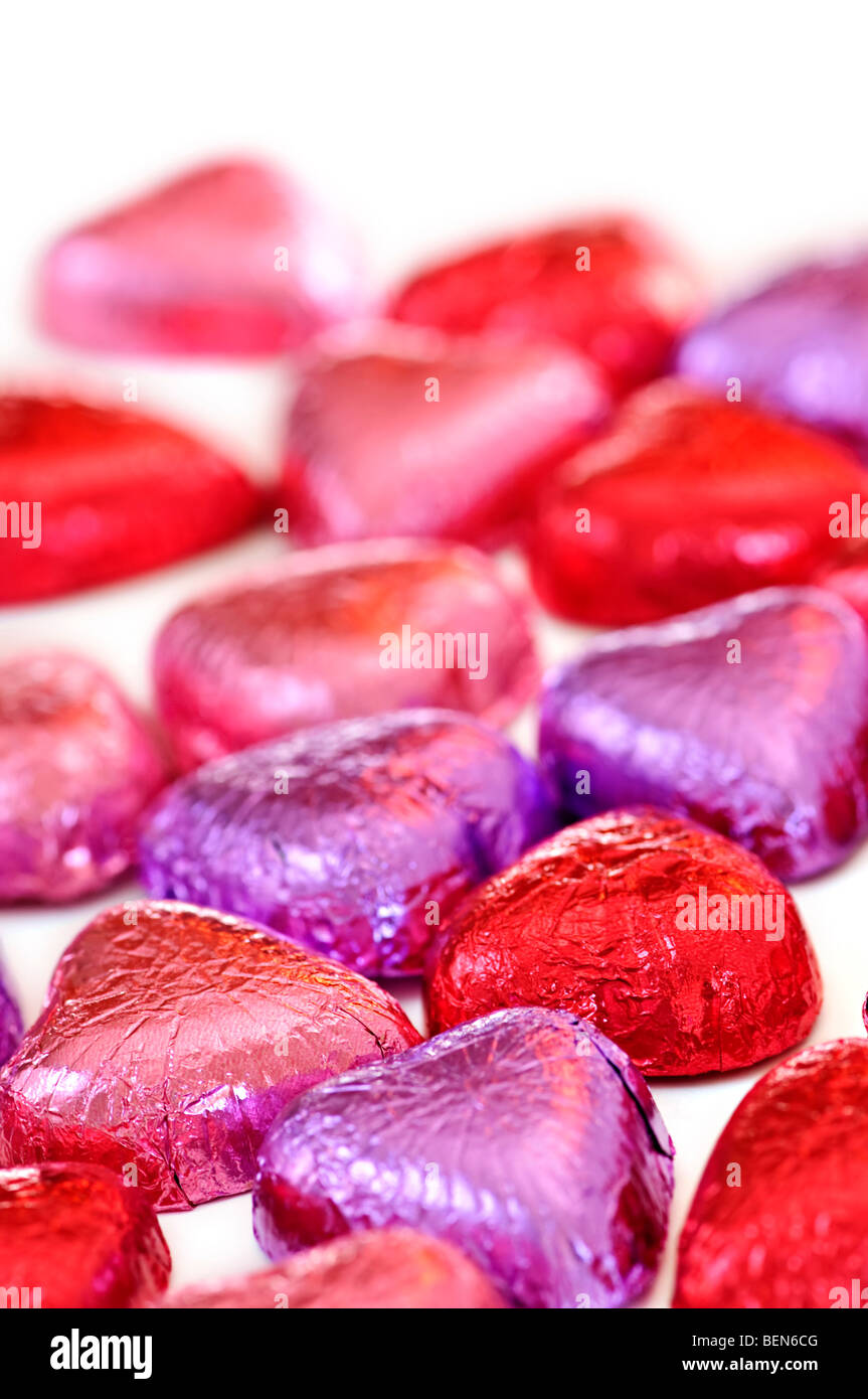 Valentine's chocolates wrapped in red and purple foil on white ...