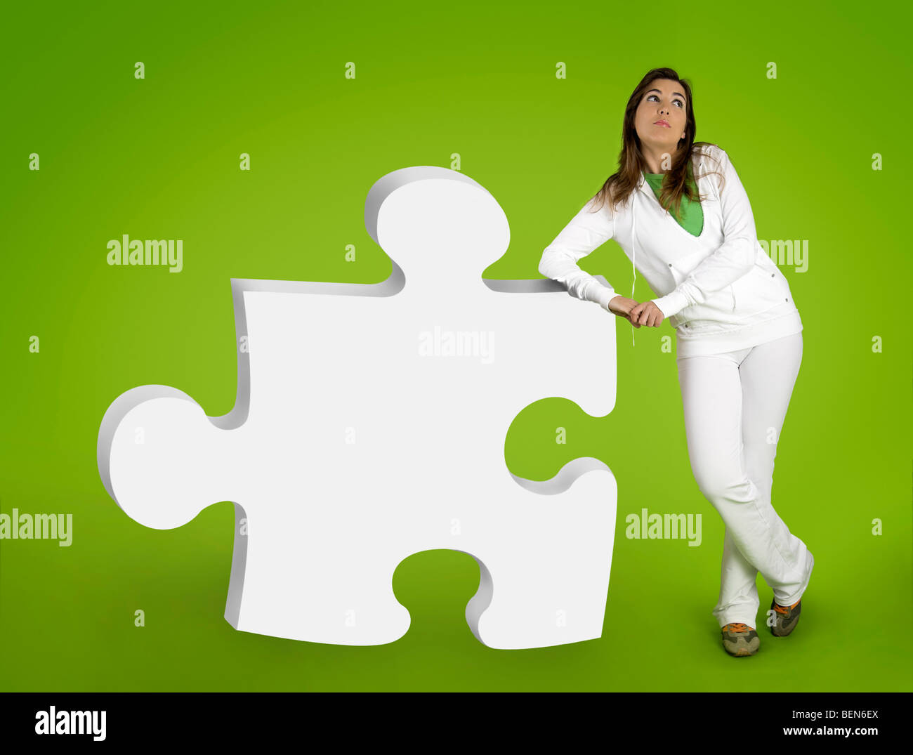 Woman contemplating questions with 3D puzzle form on a green background ...