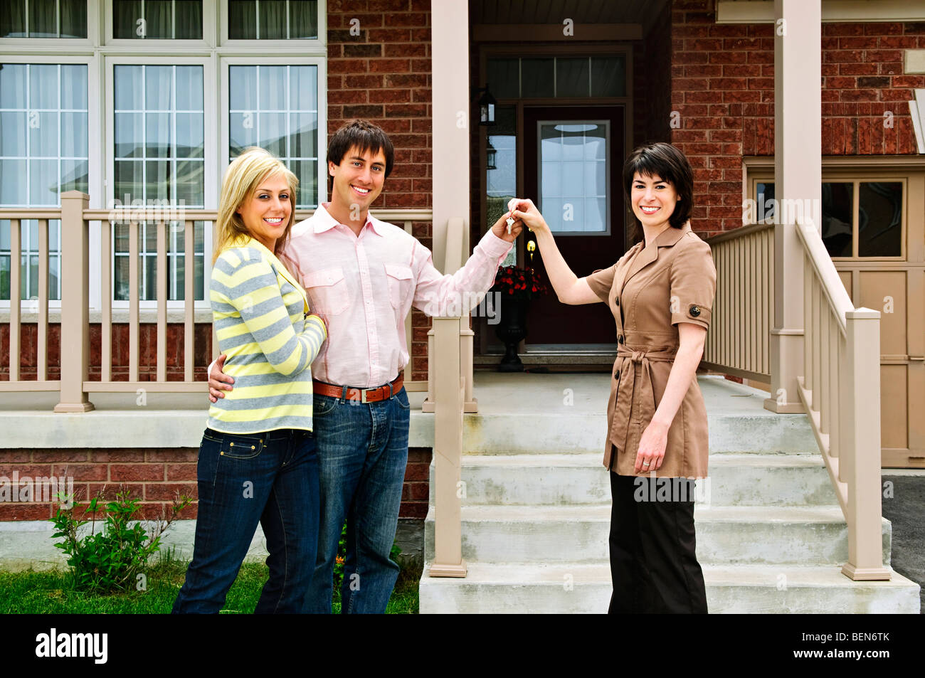 Happy couple getting keys to new house from real estate agent Stock ...