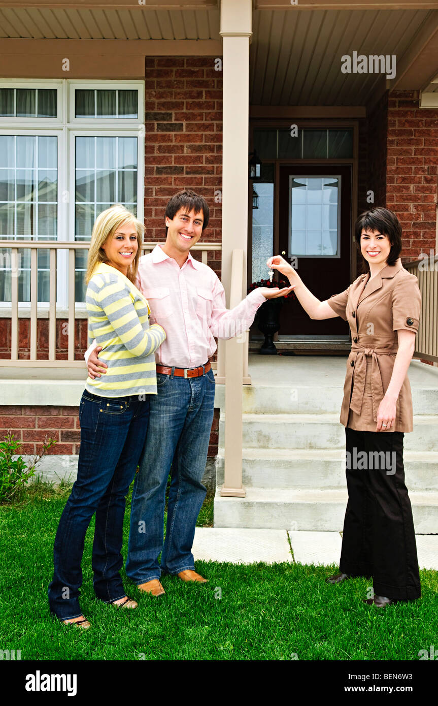Happy couple getting keys to new house from real estate agent Stock ...