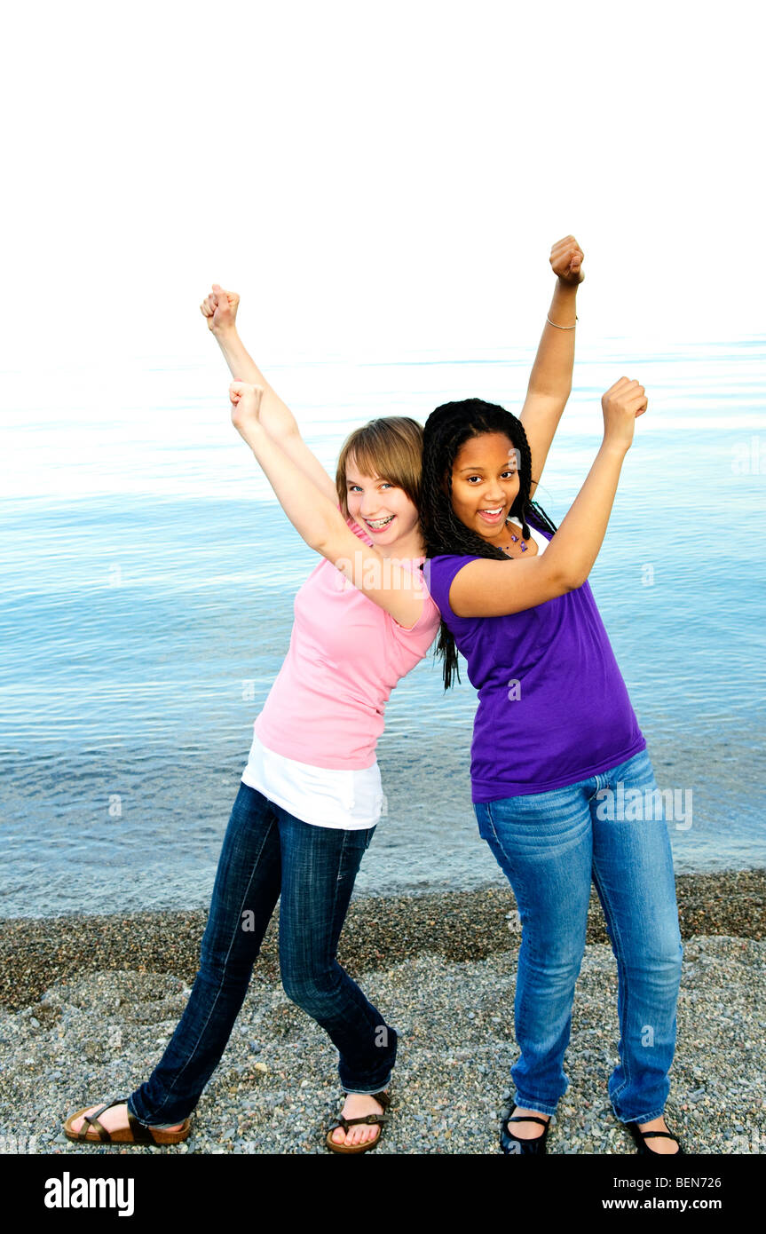 Portrait of two teenage girl friends raising arms Stock Photo - Alamy