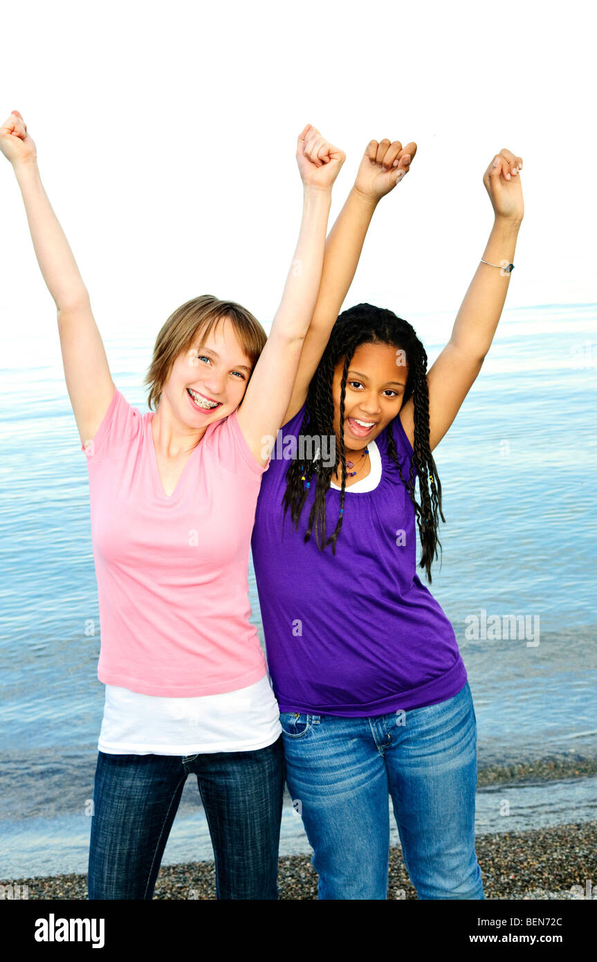 Portrait of two teenage girl friends raising arms Stock Photo - Alamy