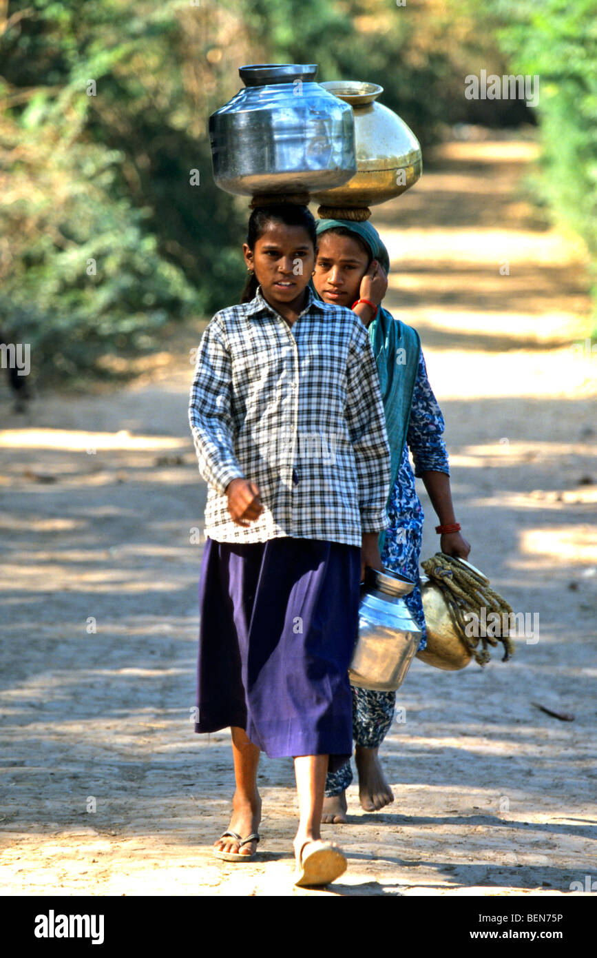 Girls carrying water on their heads on the way to well in Jatoli ...